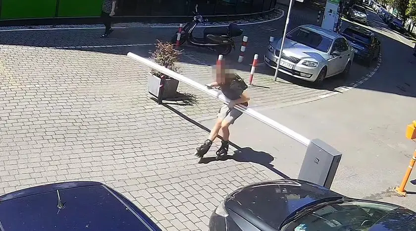 Kraków. Telefon w ręce podczas jazdy na rolkach i kolizja ze szlabanem. Nagranie z monitoringu ...